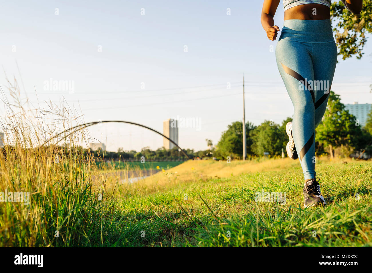 Legs of mixed race woman running in grass near waterfront Stock Photo ...
