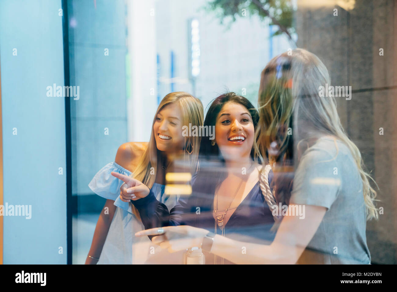 Smiling women window shopping Stock Photo - Alamy