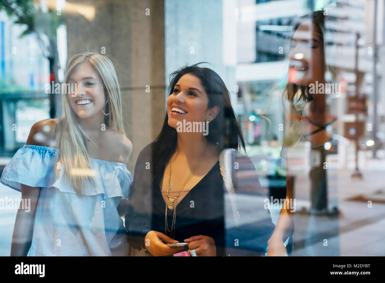 Smiling women window shopping Stock Photo - Alamy