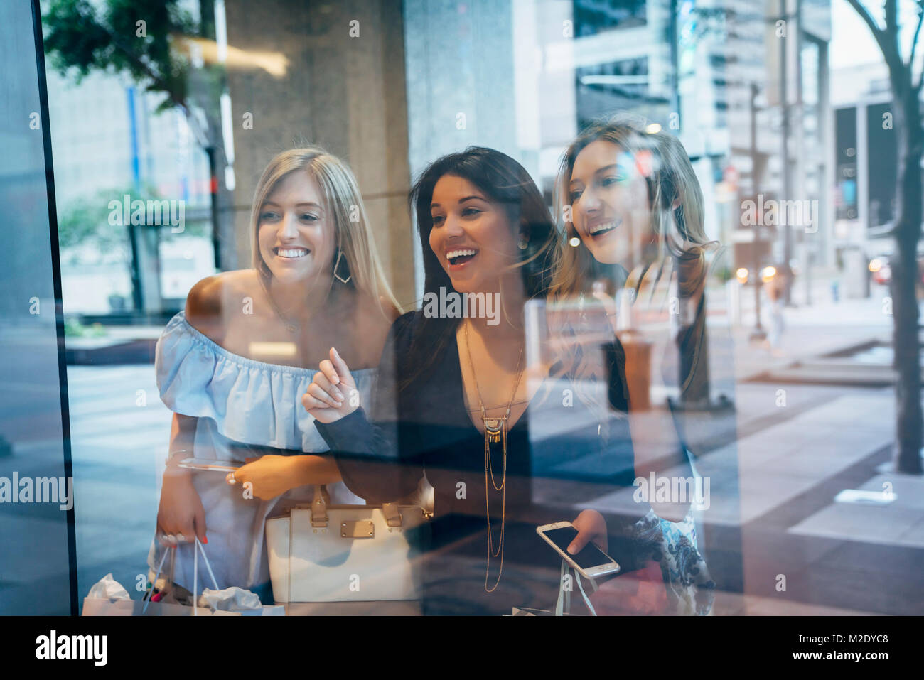 Smiling women window shopping Stock Photo - Alamy