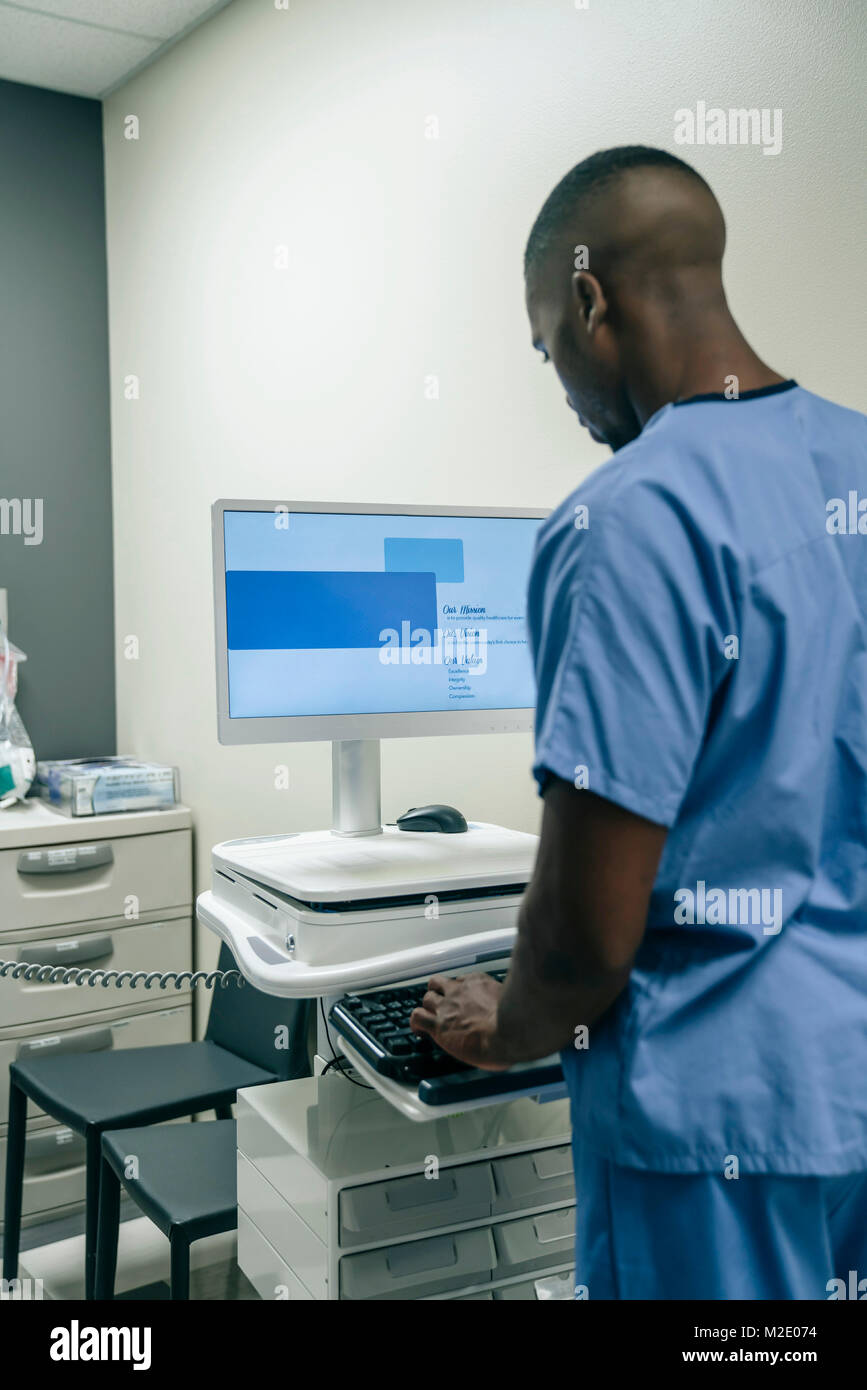 Black doctor using computer in hospital Stock Photo - Alamy