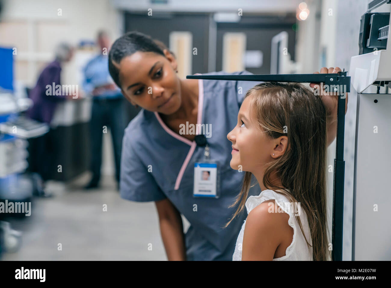 Nurse measuring height of girl in hospital Stock Photo - Alamy