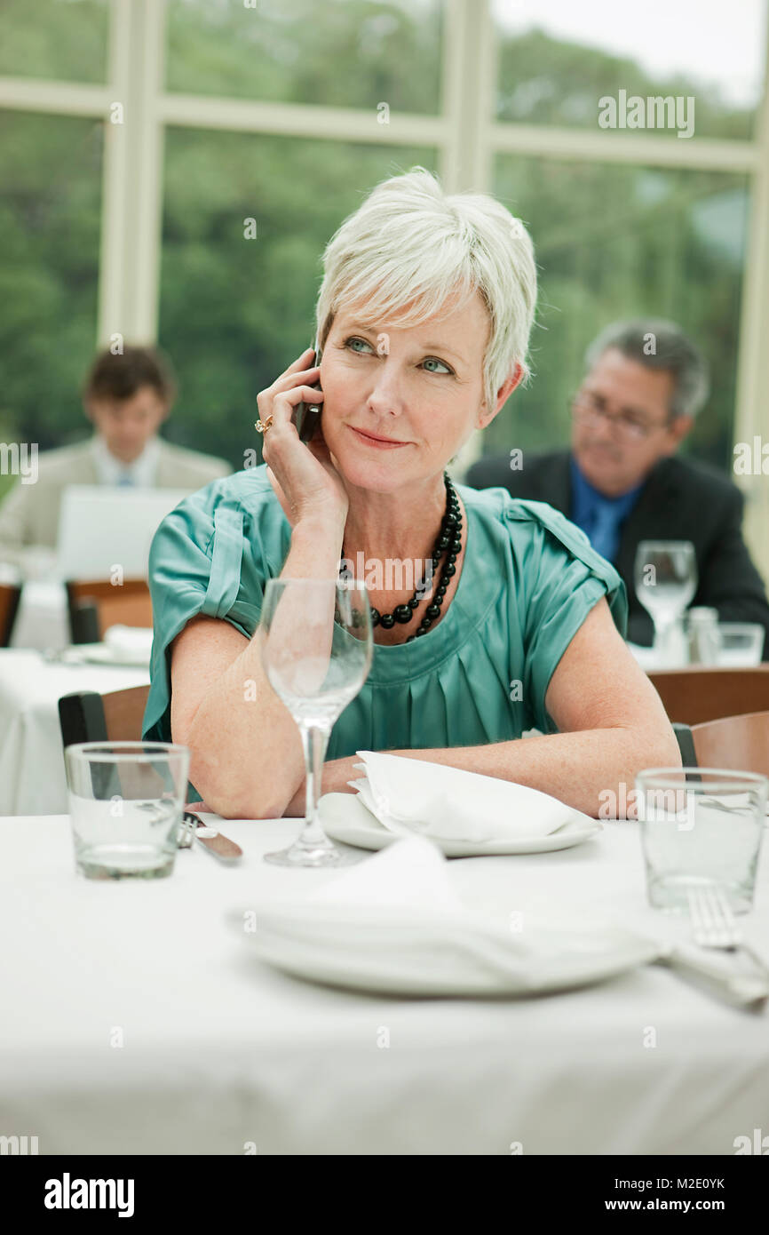 Businesswoman talking on cell phone in restaurant Stock Photo - Alamy