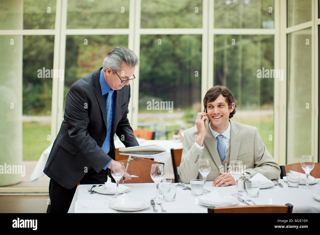 Hispanic businessmen leaning working at table in restaurant Stock Photo ...
