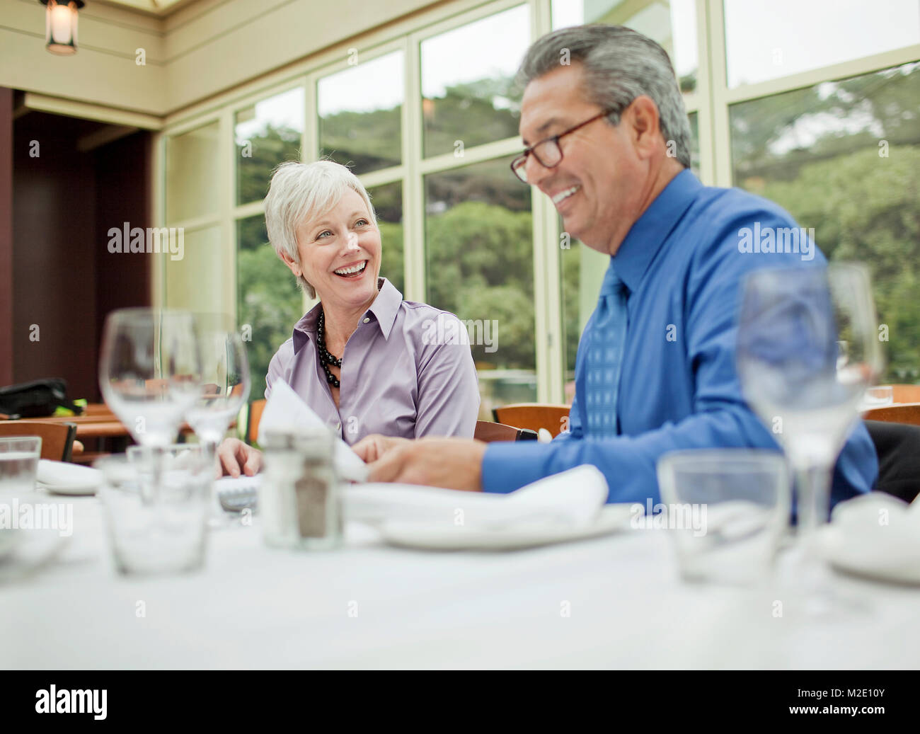 Smiling business people working at table in restaurant Stock Photo - Alamy