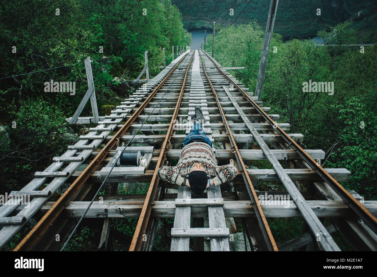 Caucasian man laying on train tracks Stock Photo - Alamy