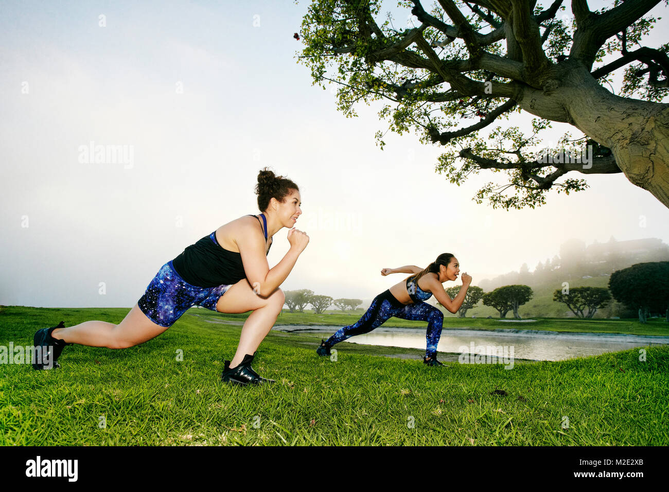 Mixed race women exercising near lake Stock Photo - Alamy