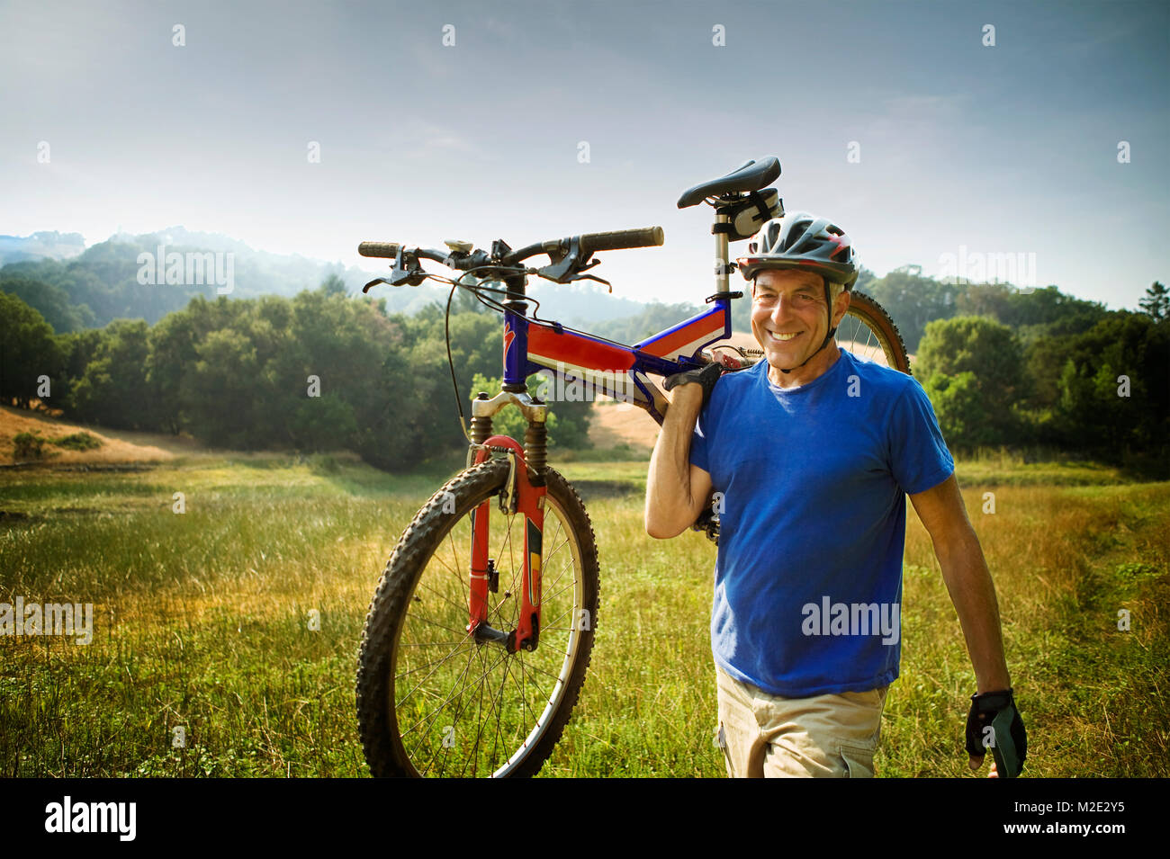 Caucasian man carrying mountain bike Stock Photo - Alamy