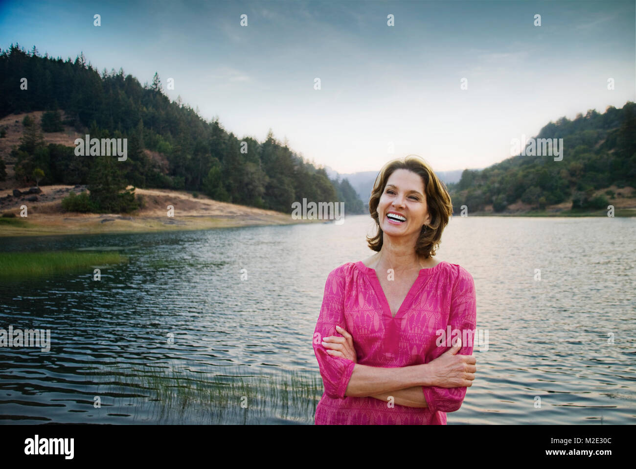 Smiling Hispanic man standing near lake Stock Photo - Alamy