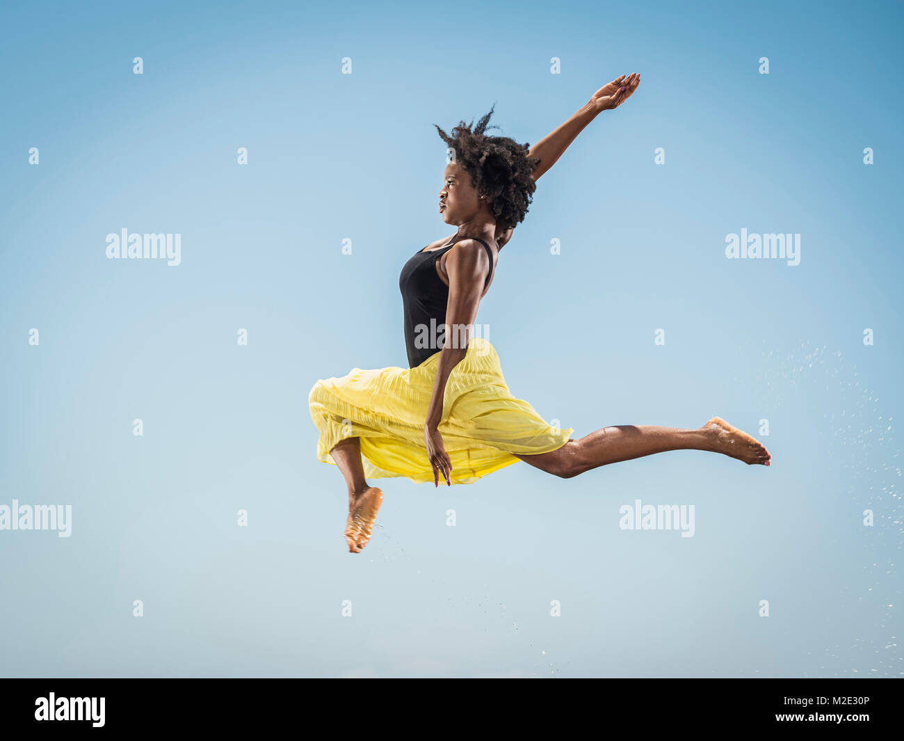 Black woman dancing and jumping Stock Photo - Alamy