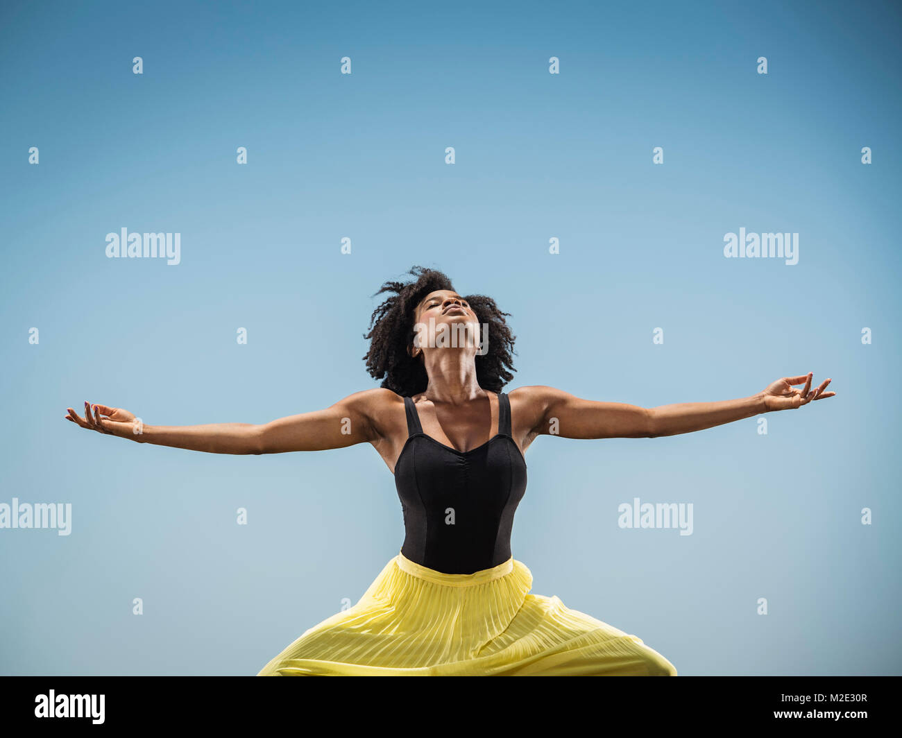 Black woman dancing with arms outstretched Stock Photo - Alamy