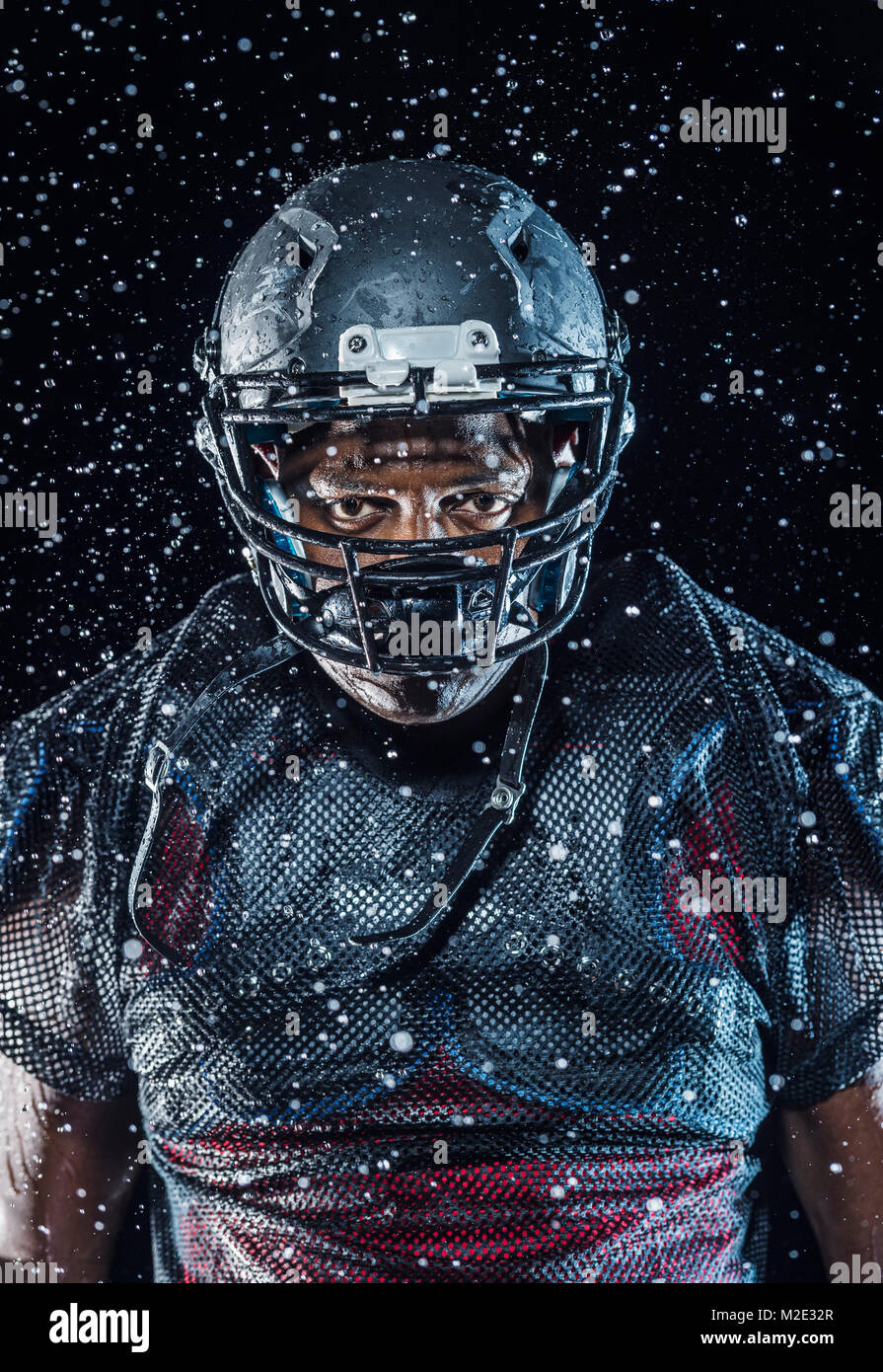 Water splashing on Black football player wearing helmet Stock Photo - Alamy