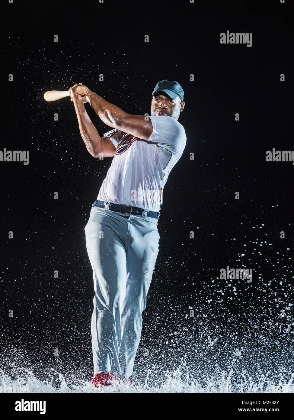 Water splashing on Black baseball player swinging bat Stock Photo - Alamy