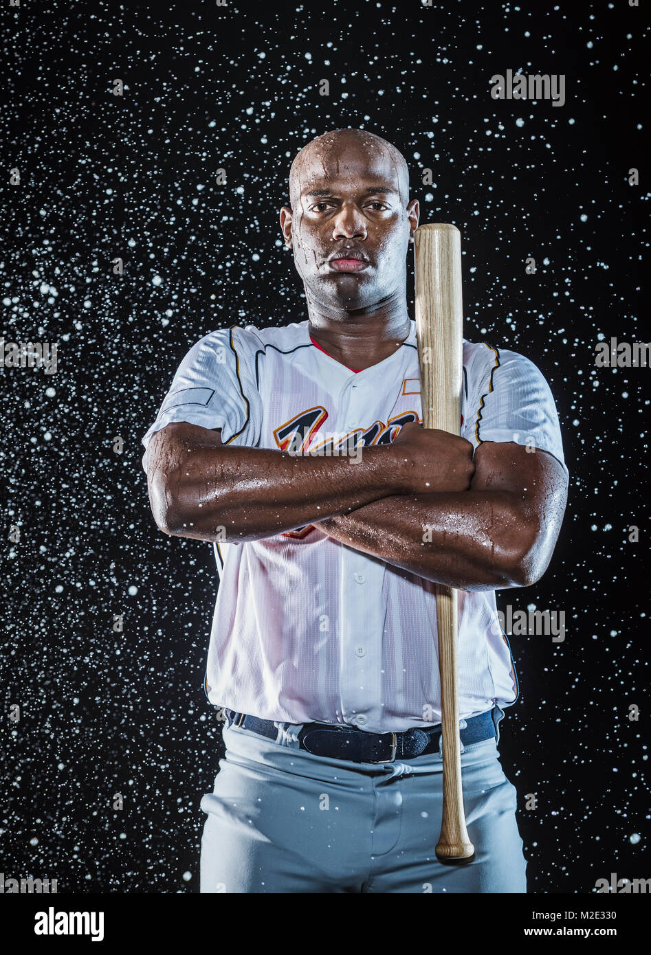 Water splashing on Black baseball player holding bat Stock Photo - Alamy