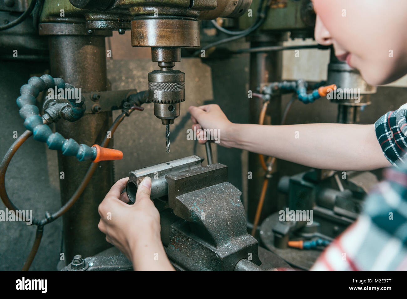 closeup of female factory worker working on milling machine company and ...