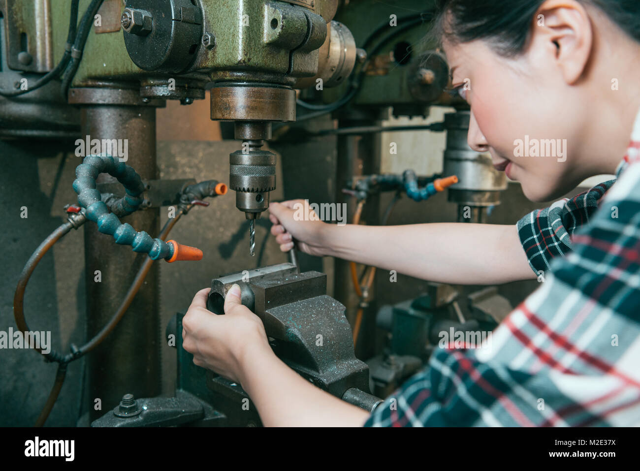 selective focus photo of smiling pretty woman worker drilling parts in ...