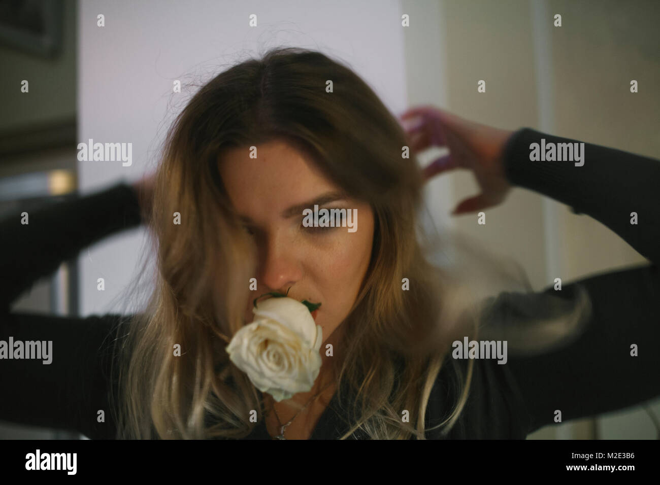 Portrait of Caucasian woman biting flower Stock Photo - Alamy