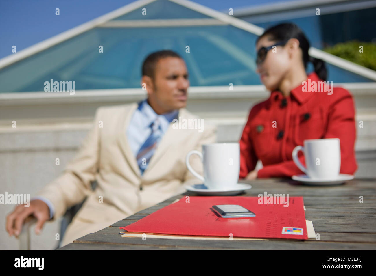 Mail and coffee cups near couple talking outdoors Stock Photo - Alamy