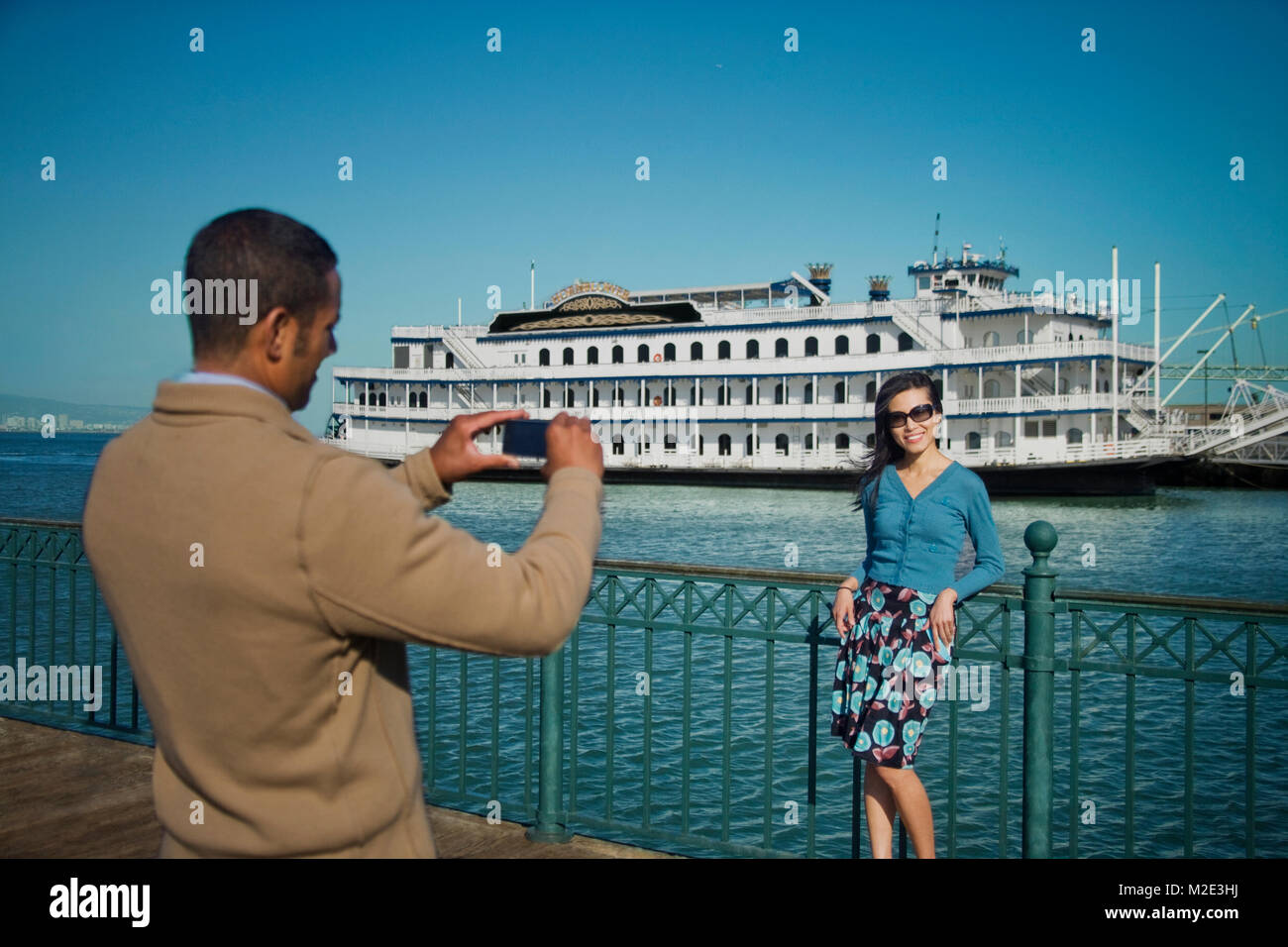 Man photographing woman at waterfront Stock Photo - Alamy