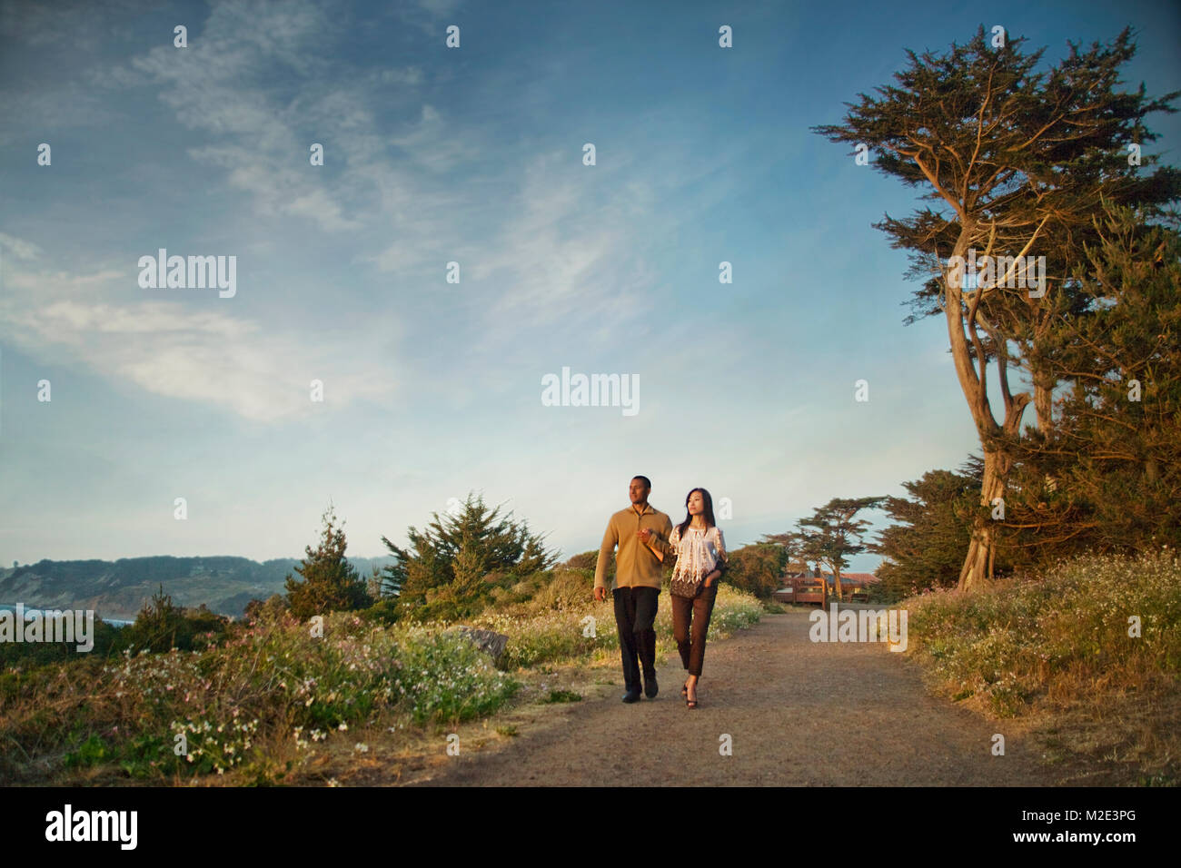 Couple walking on path in park Stock Photo - Alamy