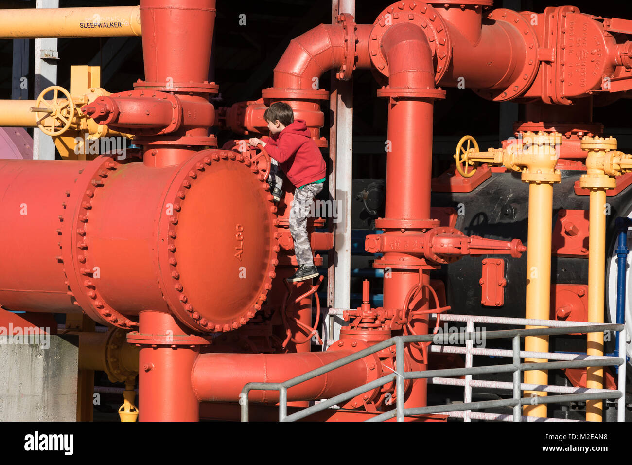 Boy climbing on pipes of the old gas works in Gas Works Park, Seattle ...