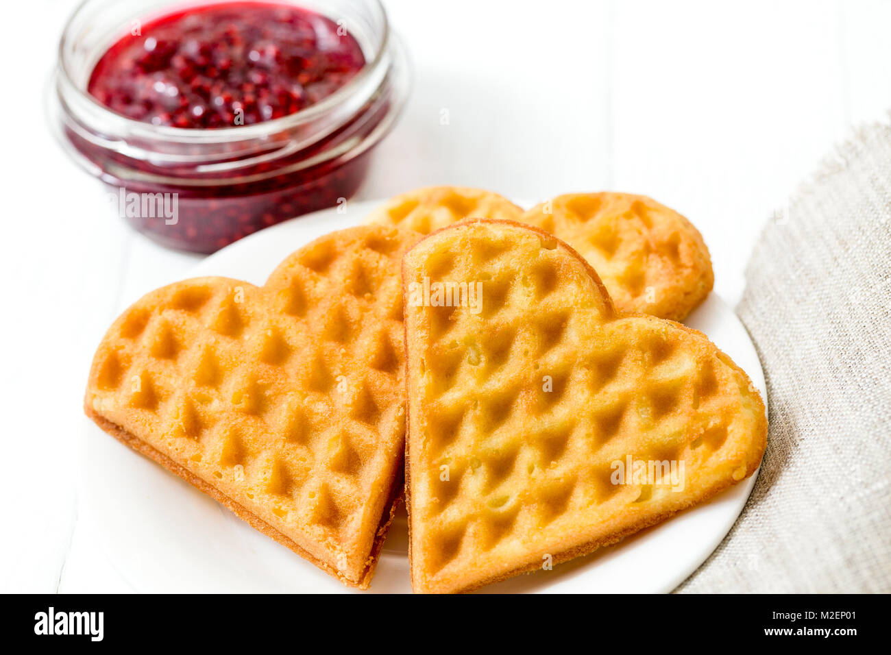 Viennese waffles, raspberry jam in a glass bowl on a white background ...