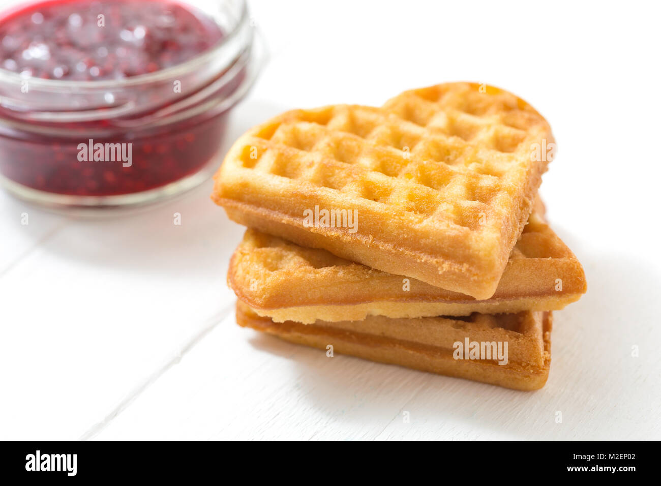 Viennese waffles, raspberry jam in a glass bowl on a white background ...