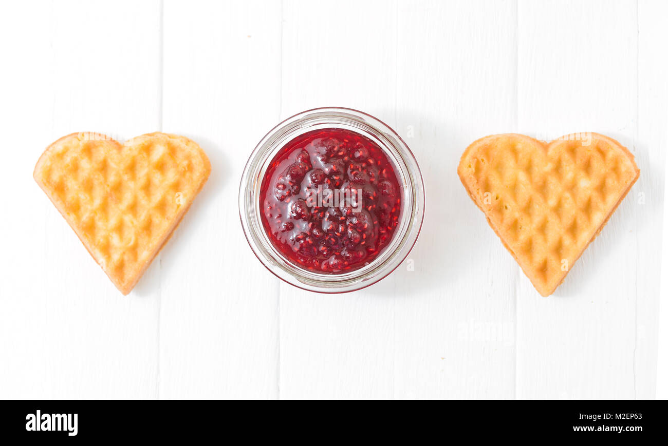 Viennese waffles, raspberry jam in a glass bowl on a white background ...