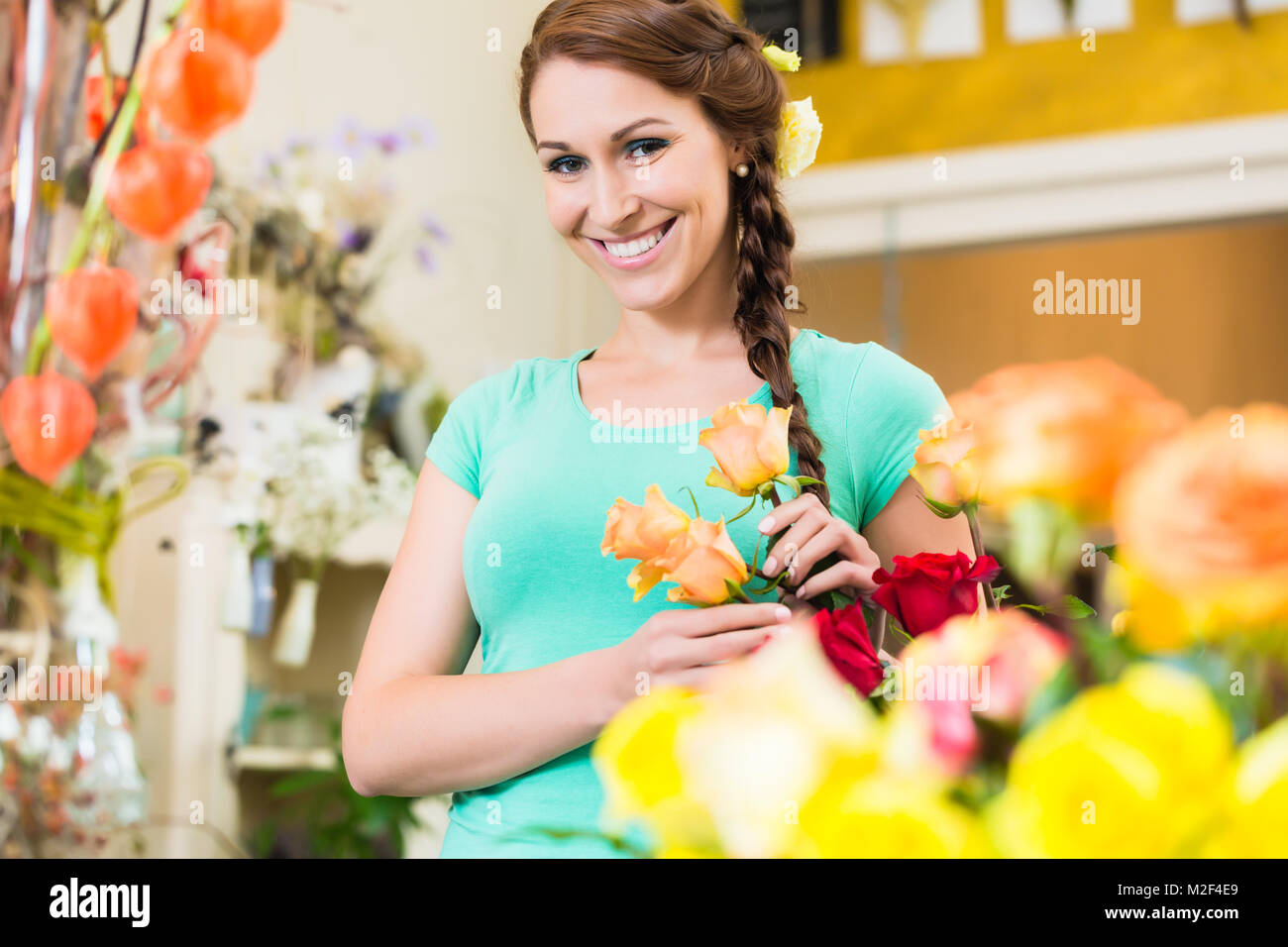 Florist or customer with flowers in shop looking at camera Stock Photo ...