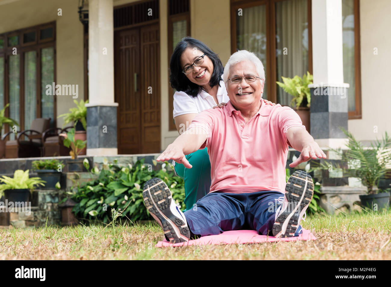 Cheerful senior woman helping her partner during workout session ...