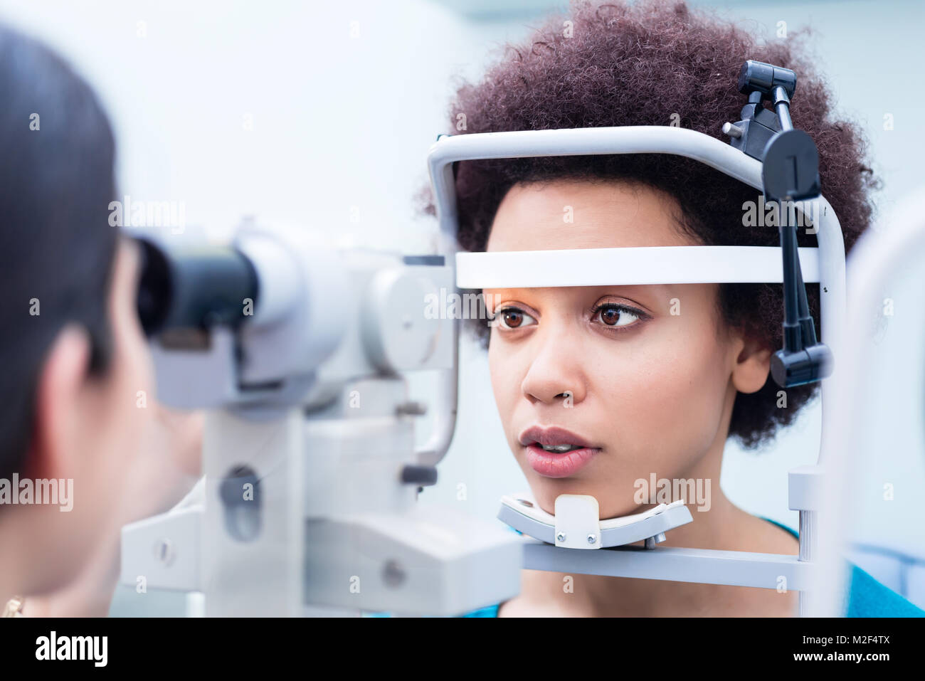 Optician measuring women eyes with refractometer Stock Photo - Alamy