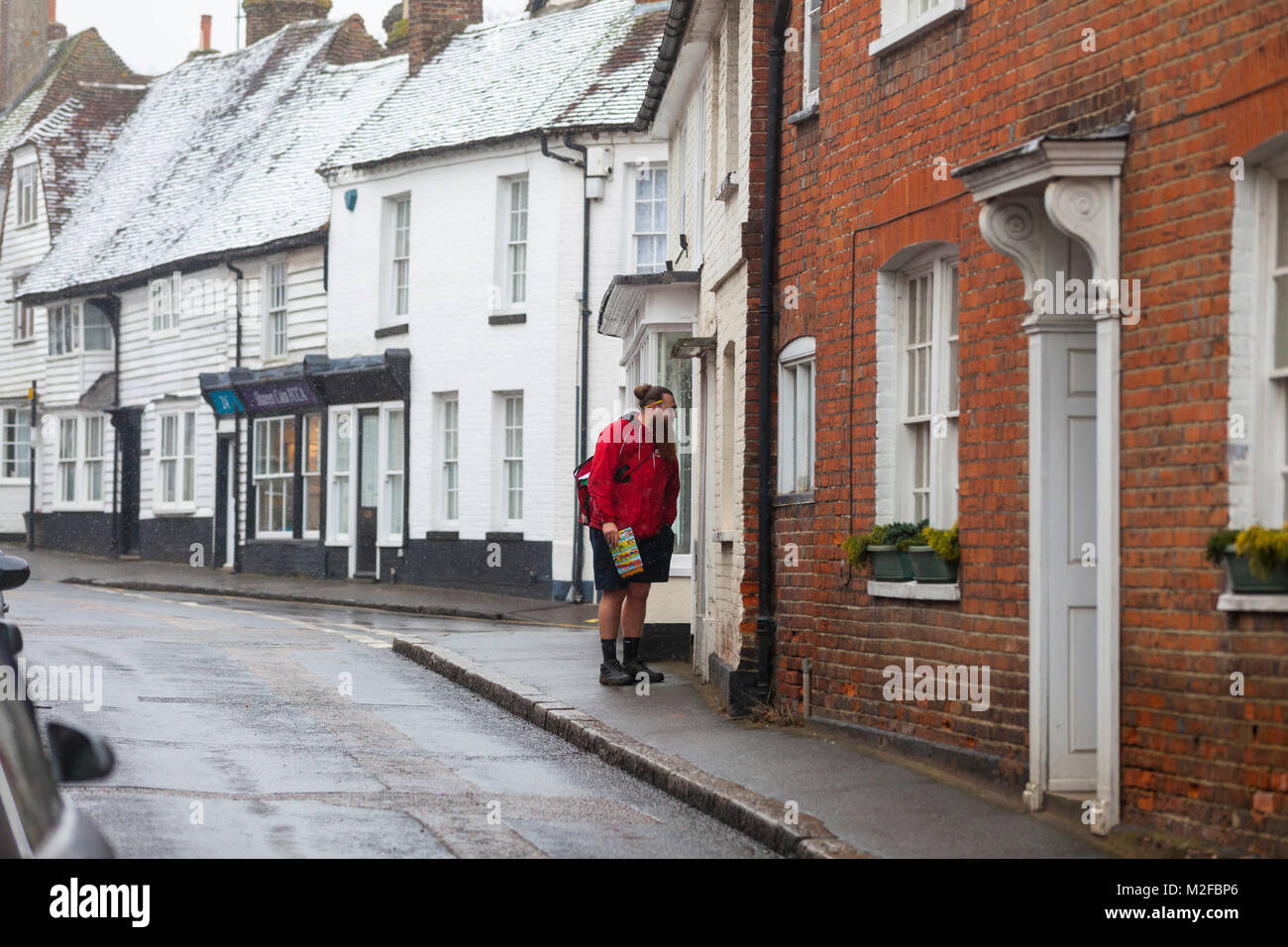 Charing village with rooftops covered in snow and local postman, kent ...