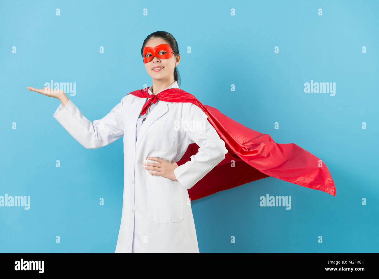 happy professional woman superhero doctor standing in blue background ...