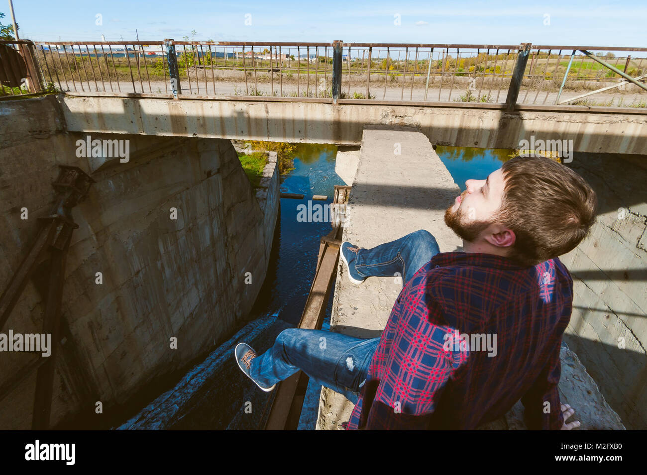 young man with a beard. a trip to the lake, an abandoned old dam, a ...