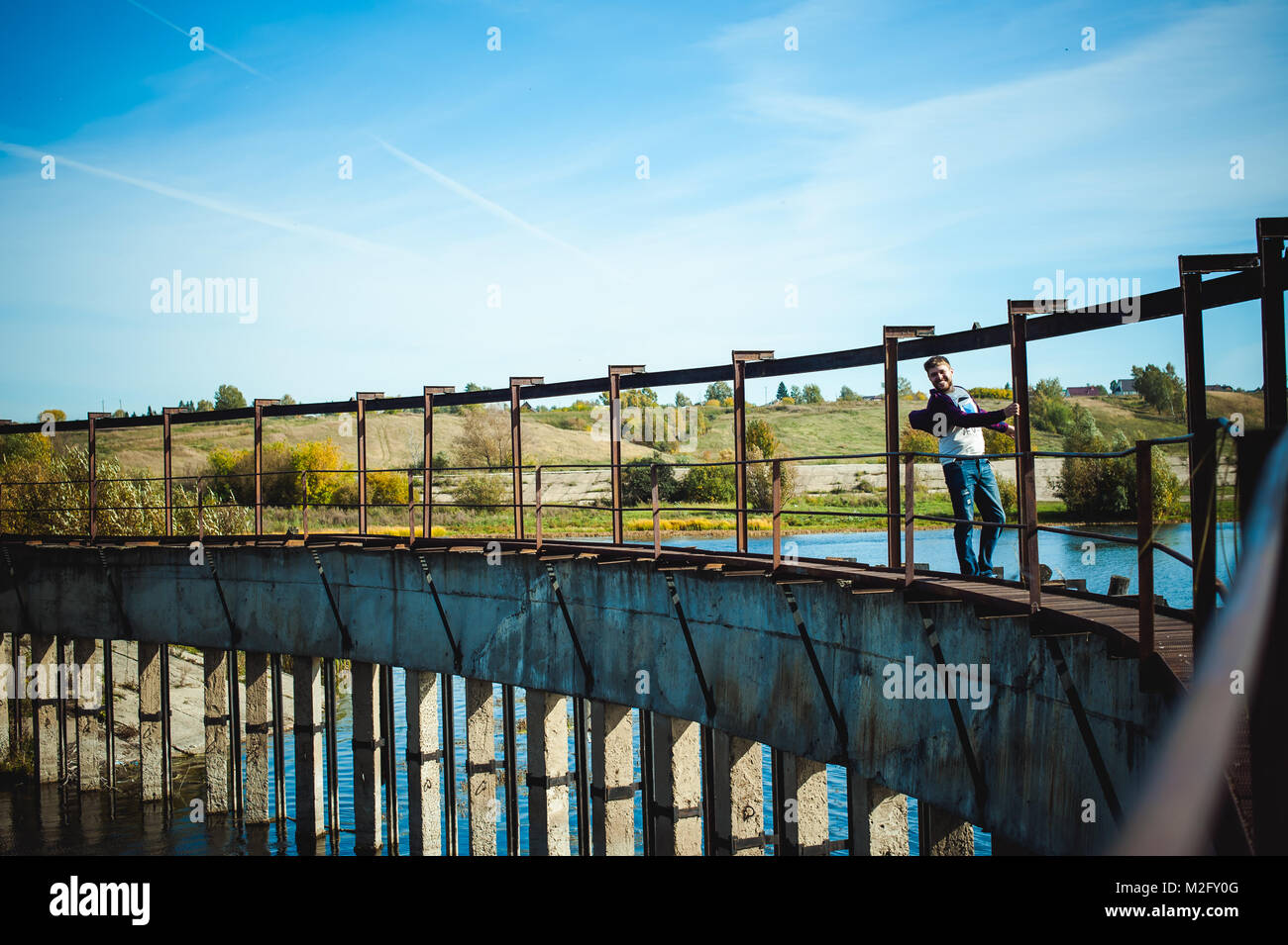 young man with a beard. a trip to the lake, an abandoned old dam, a ...