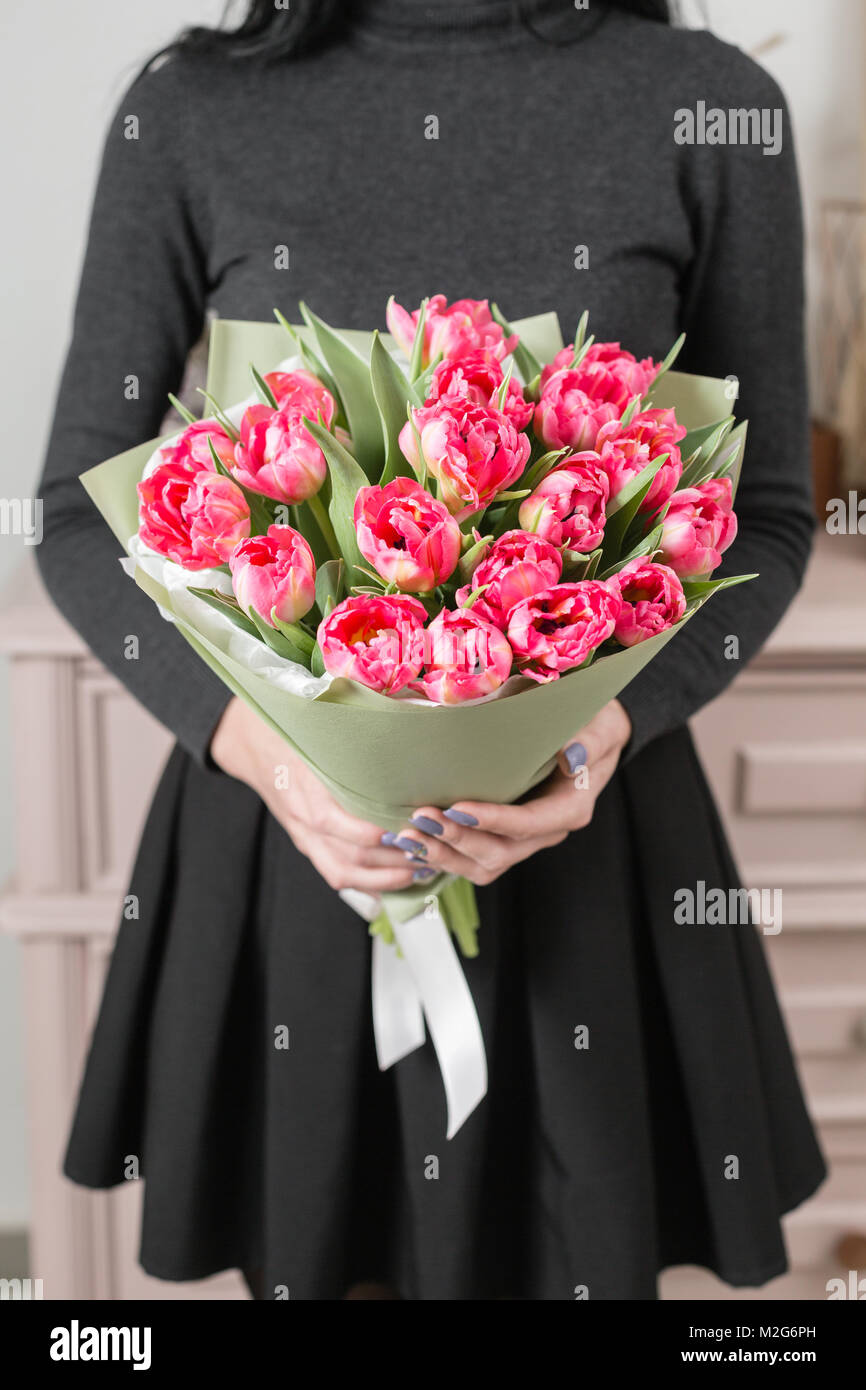 beautiful luxury bouquet of pink tulips flowers in woman hand. the work of the florist at a ...