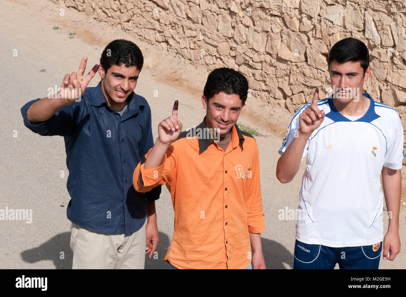Three young men of Ramadi, Iraqi, smile while showing their dyed purple ...