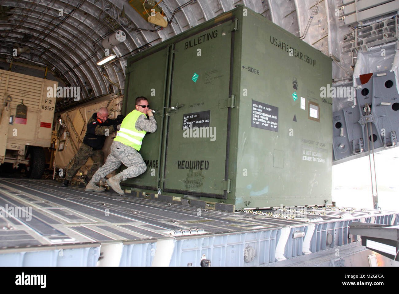 Airmen from the multinational Heavy Airlift Wing move a billeting BEAR ...
