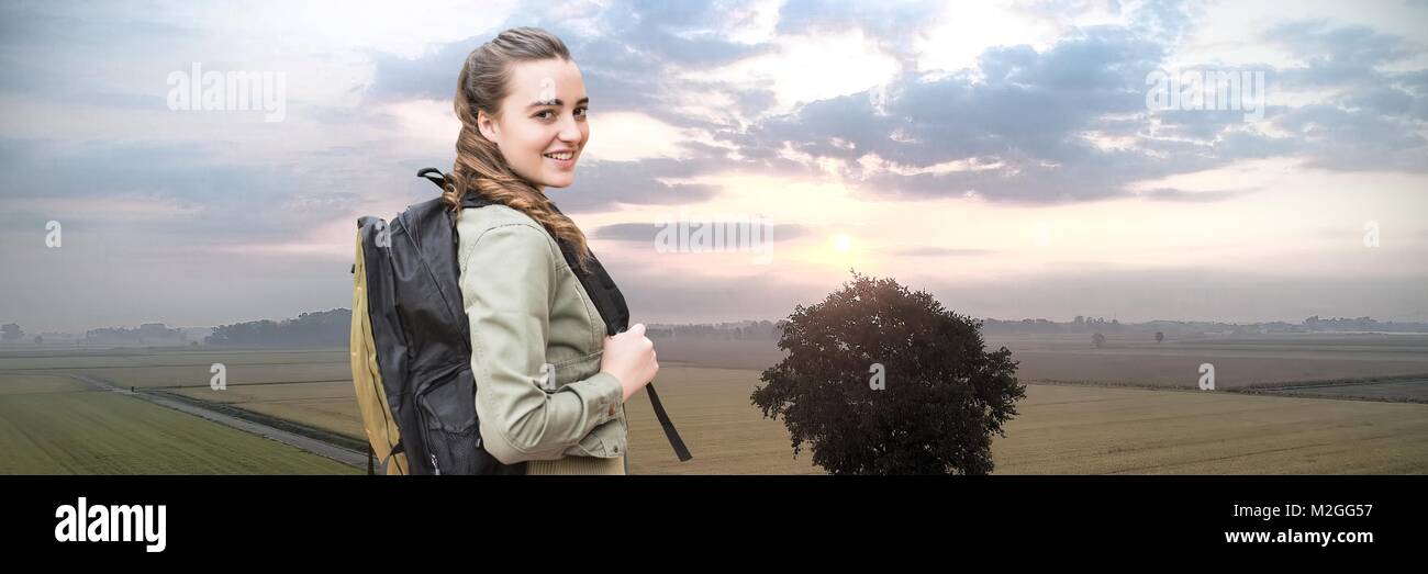 Travelling woman with bag in front of landscape Stock Photo - Alamy