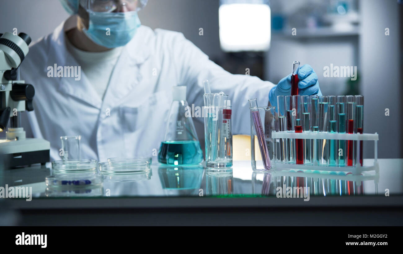 Lab worker putting medical blood sample in place after examining for ...
