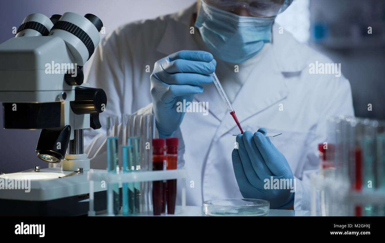 Researcher conducting blood test at modern medical laboratory, health ...