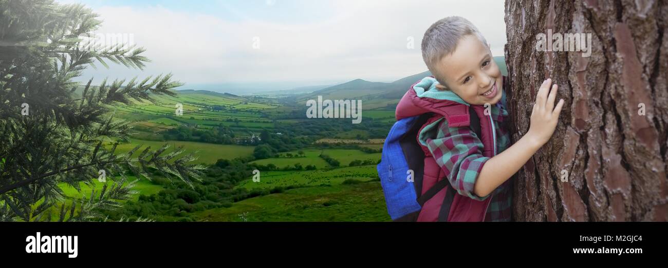 Travelling boy with bag in front of landscape holding tree Stock Photo ...