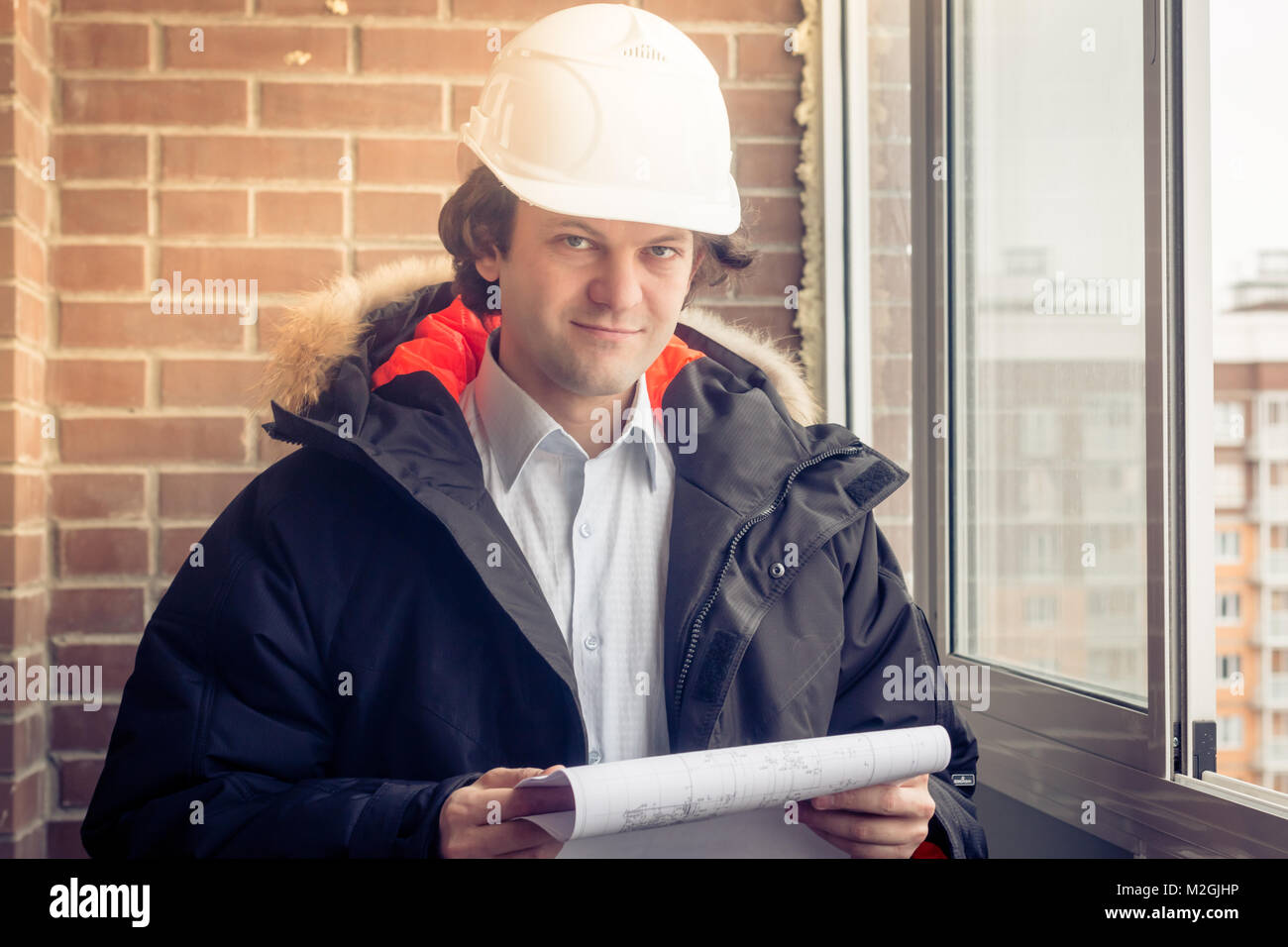 Portrait of an architect builder studying layout plan of the rooms ...