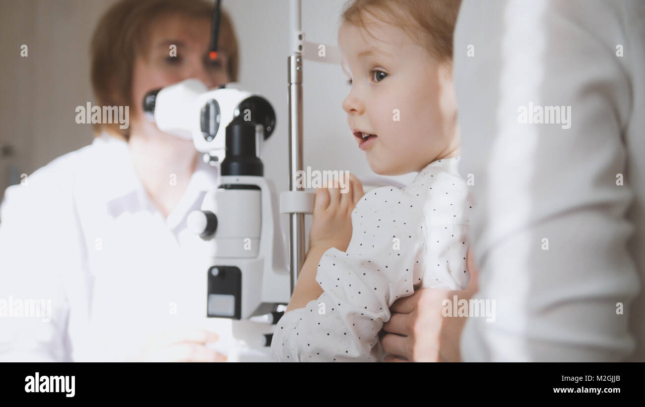 Little adorable girl in child's ophthalmology - optometrist checking ...