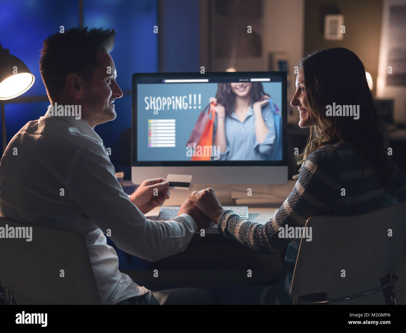 Loving couple connecting with a computer and doing online shopping late ...