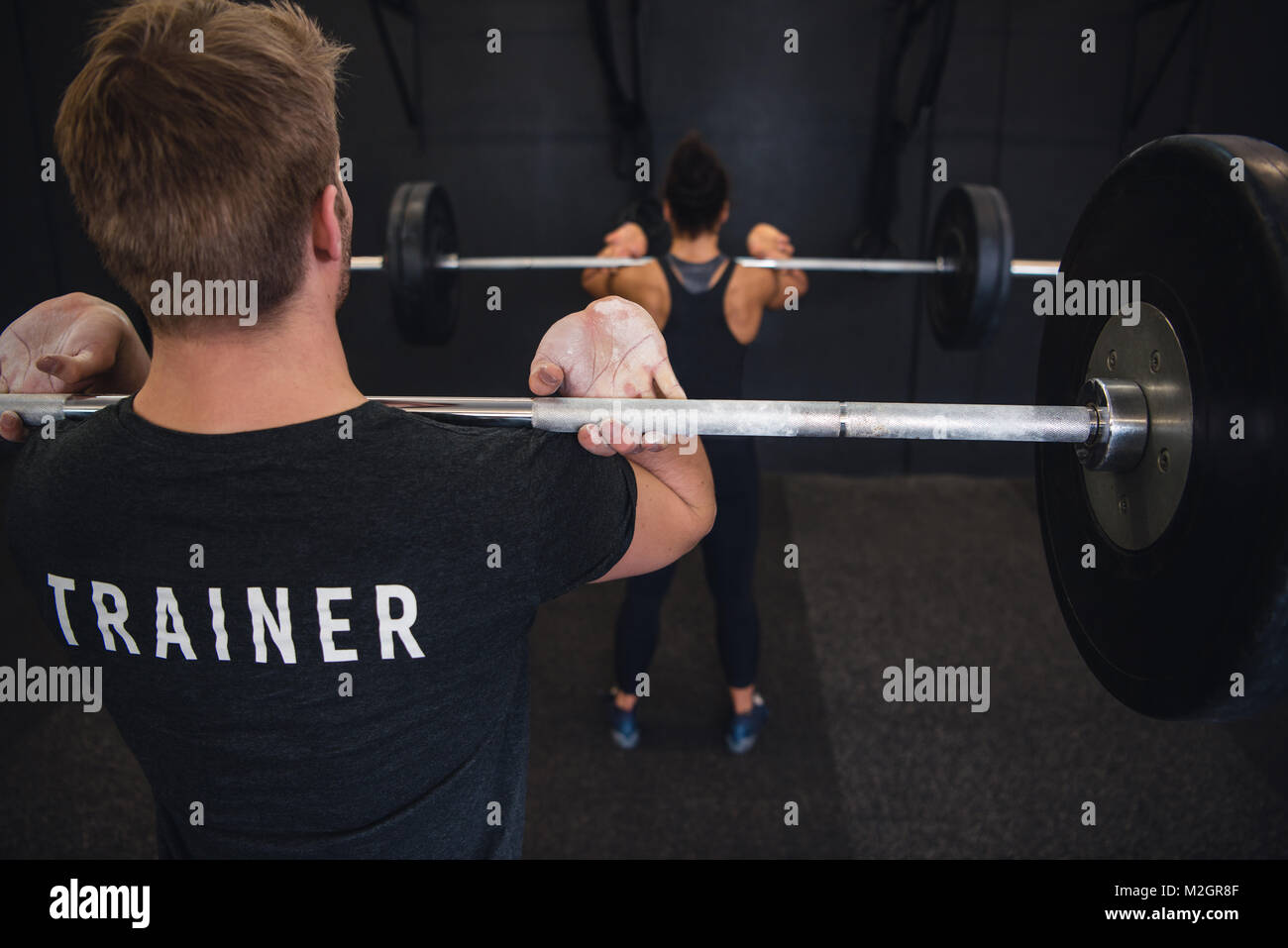Weightlifting, powerlifting, crossfit man and woman working out in gym ...