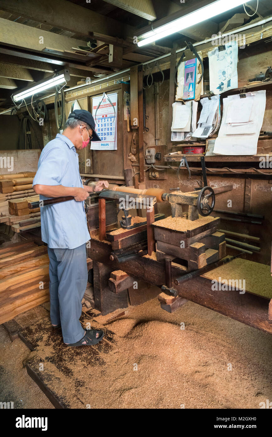 A man working wood on a lathe in a laboratory in Bangkok, Thailand ...