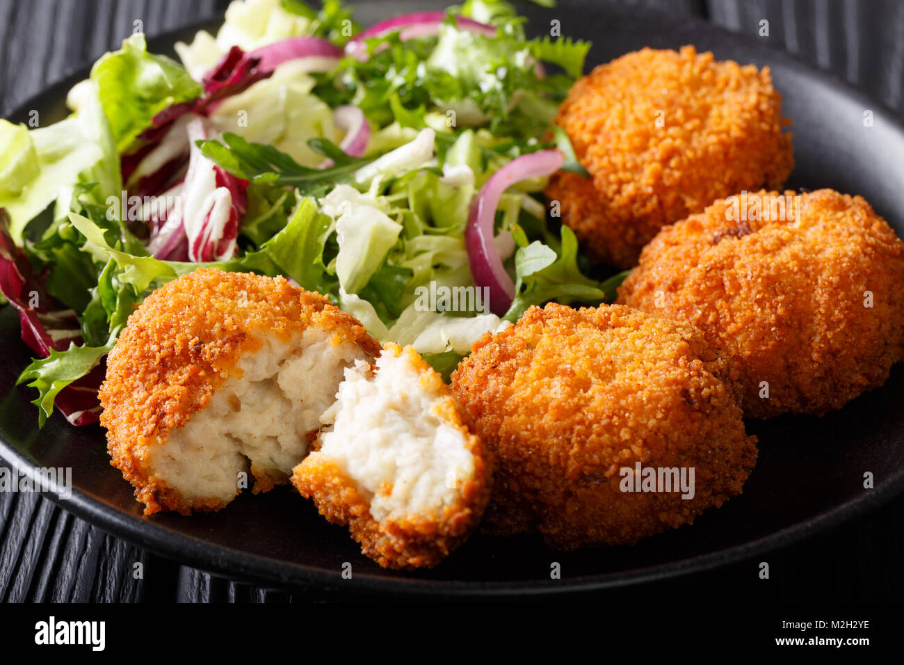 Cod cake with fresh salad on a plate close-up. horizontal Stock Photo ...