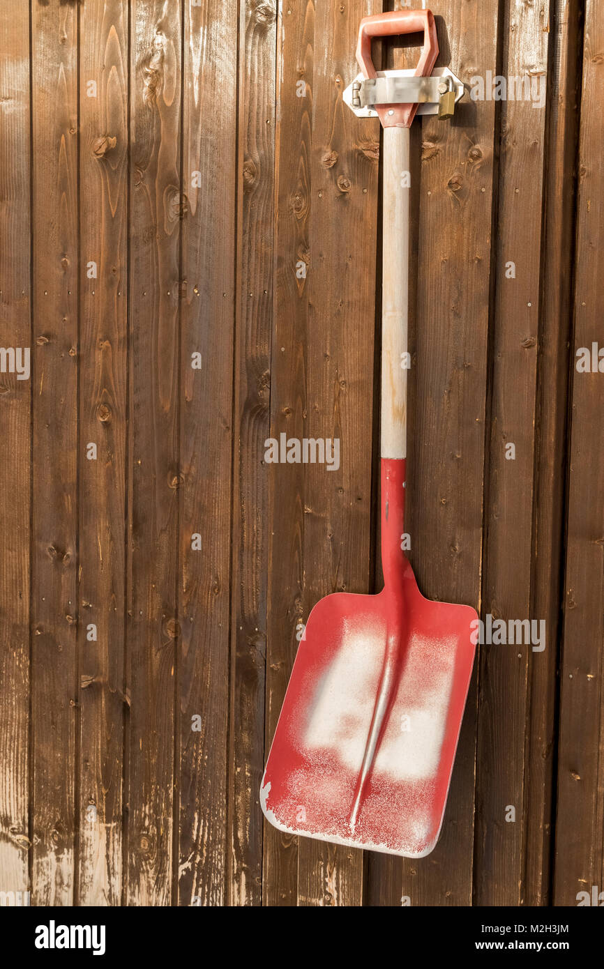 Used shovel hanging on a brown wall, secured with a lock Stock Photo ...
