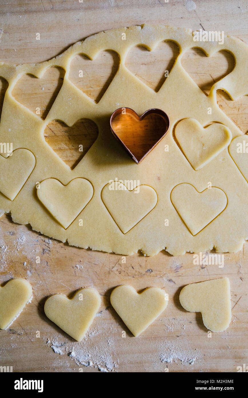 Baking Heart Shaped Cookies for valentine's day, over a wooden ...